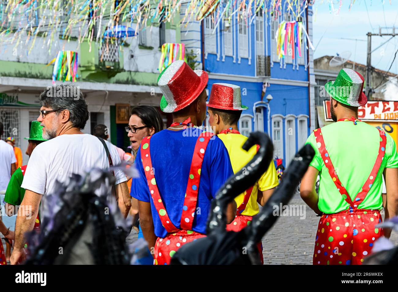A cheerful group of people wearing brightly colored clown hats and ...