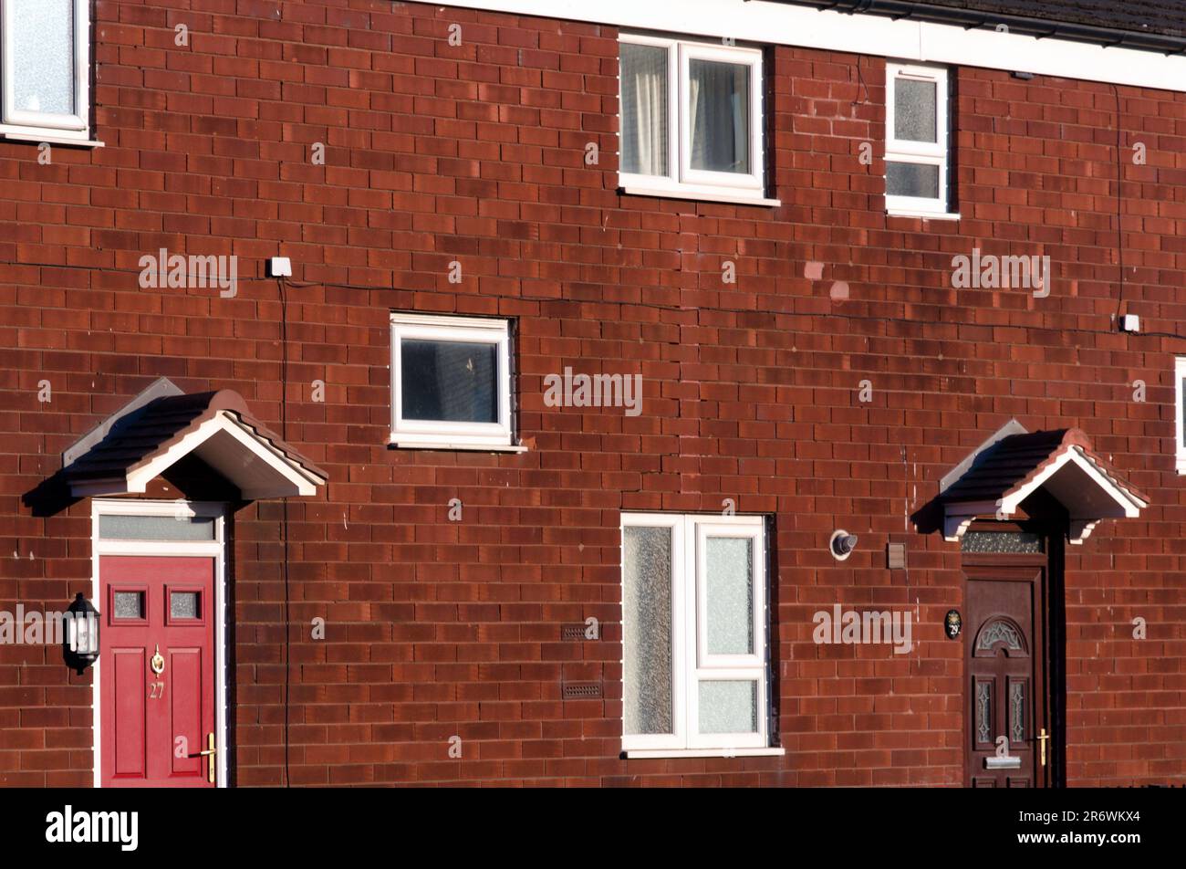 Red brick frontage of terraced houses in Manchester, UK, in bright ...