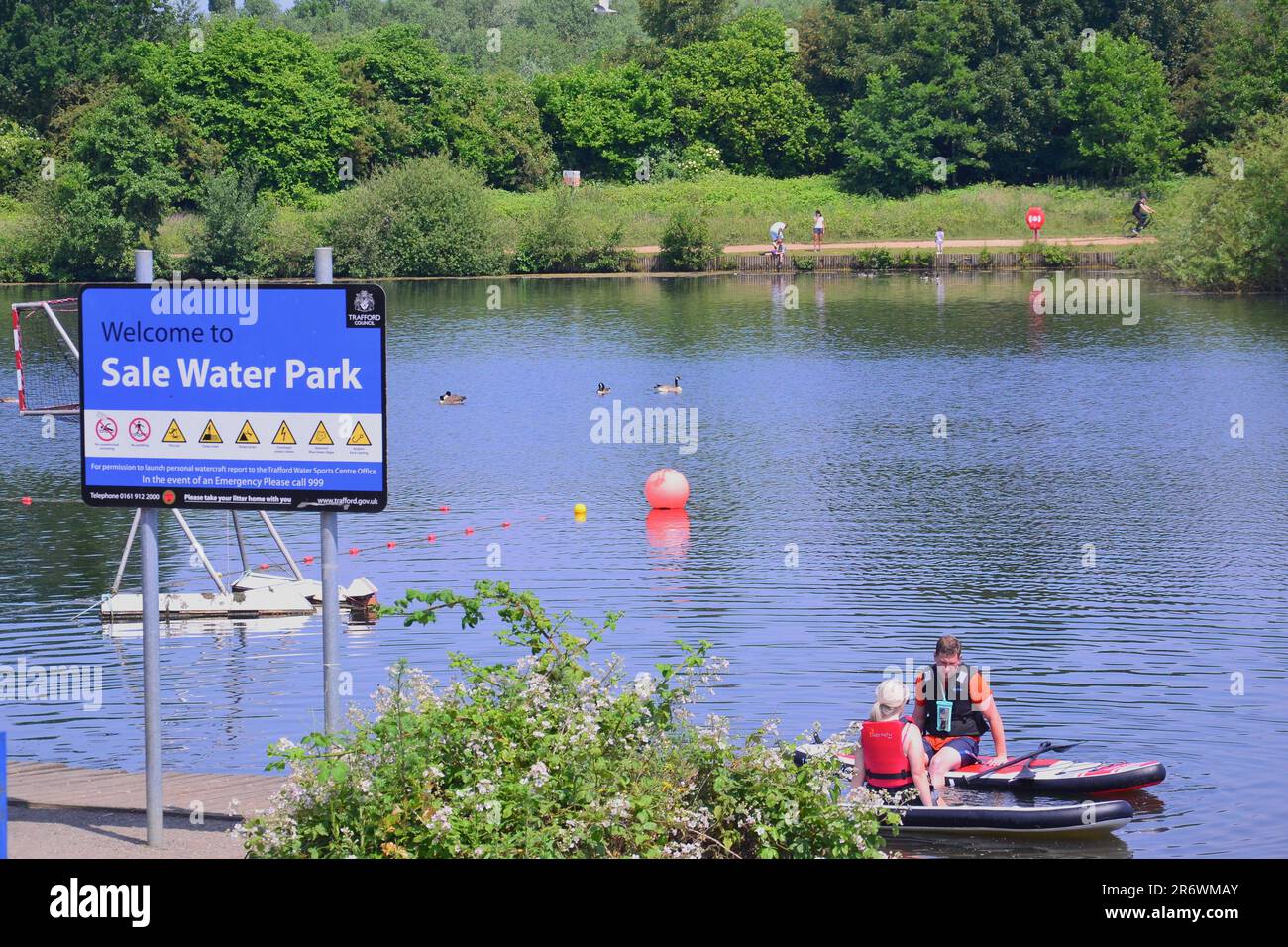 Sale Water Park, Trafford, Greater Manchester, man woman paddle boards ...