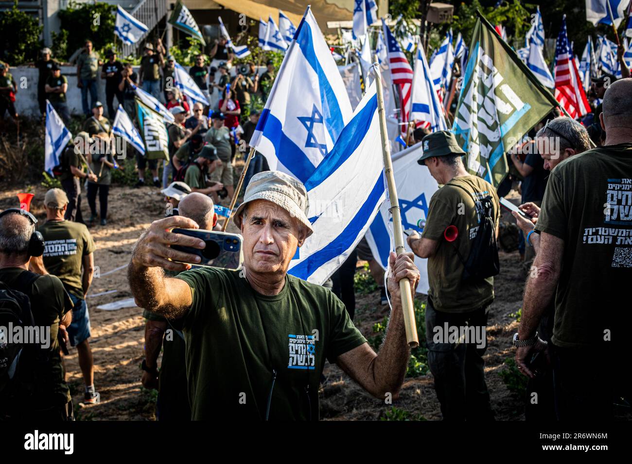 A protester takes a selfie while standing among Israeli active and ...