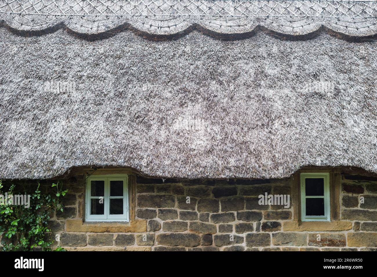 Section of a thatched roof on a limestone brick cottage Stock Photo - Alamy