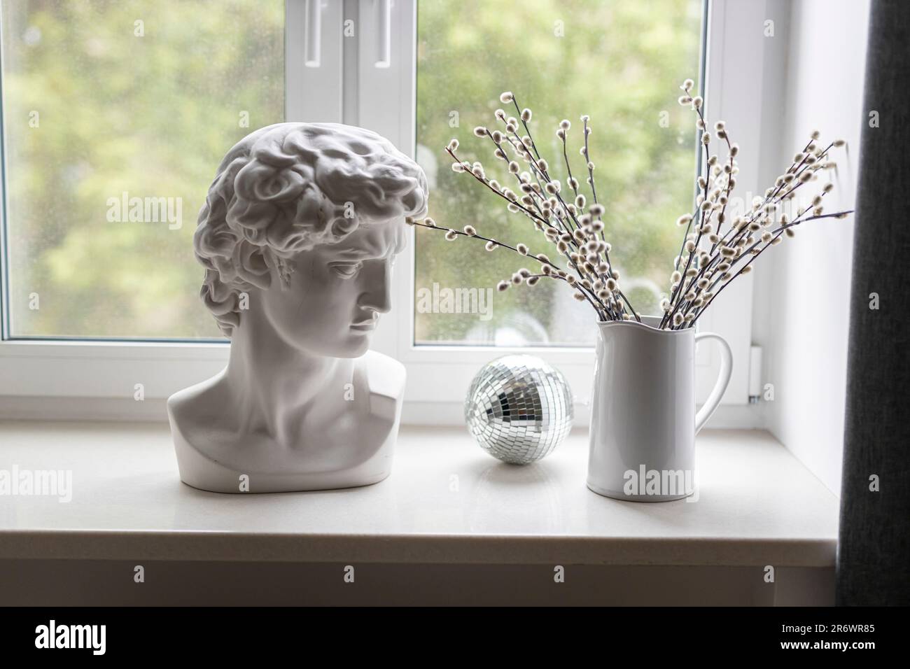 Apollo's plaster head in a white interior. a mirror disco ball and ...