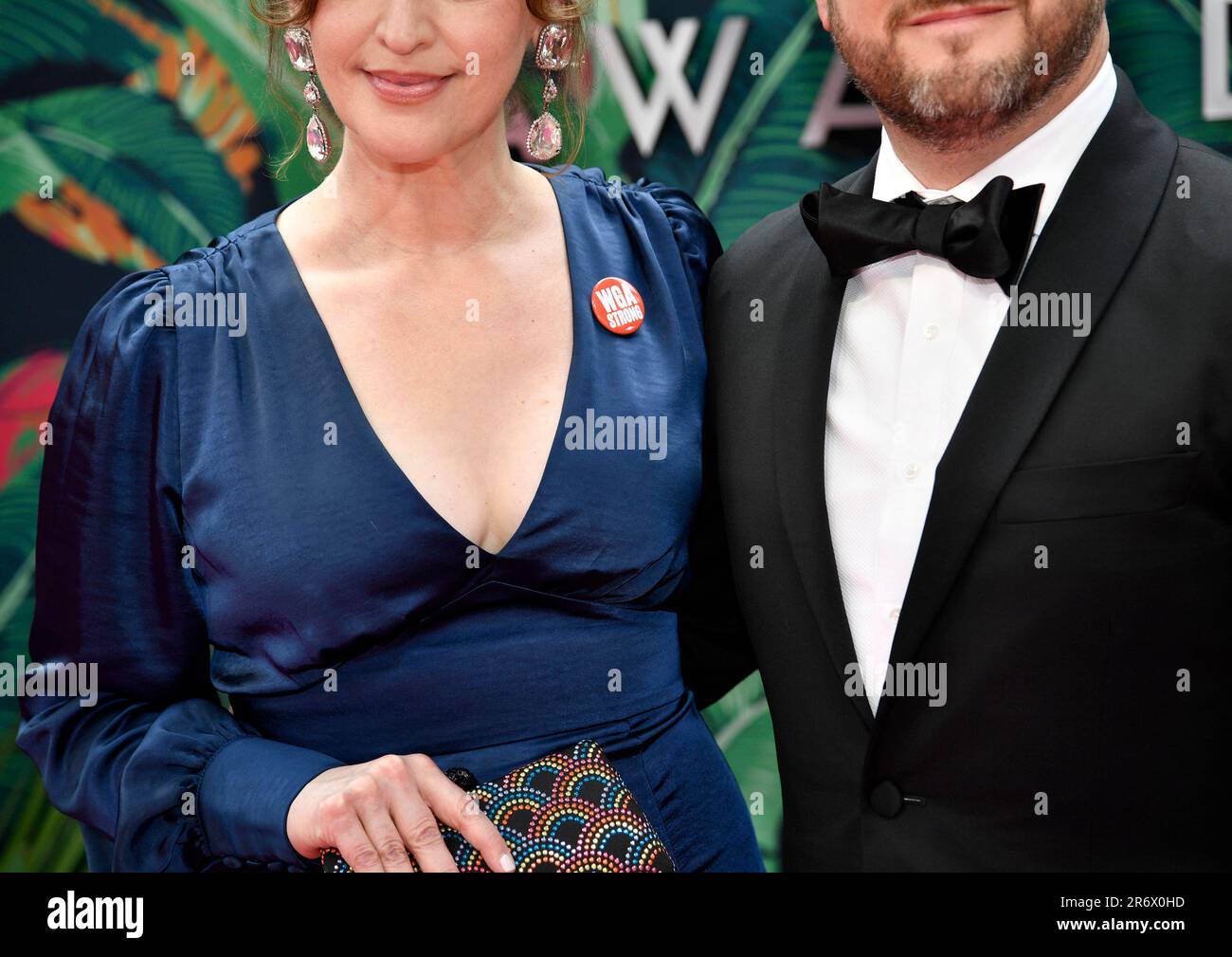 Jessica Stone, wearing a pin in support of the WGA strike, left, and ...