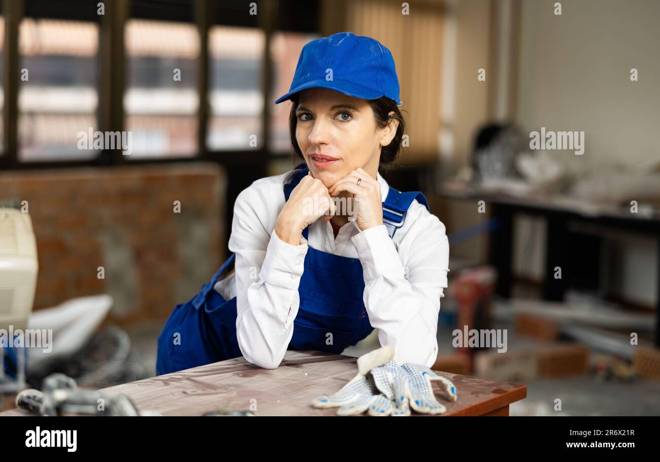 Woman foreman in blue overalls posing in house under construction Stock ...
