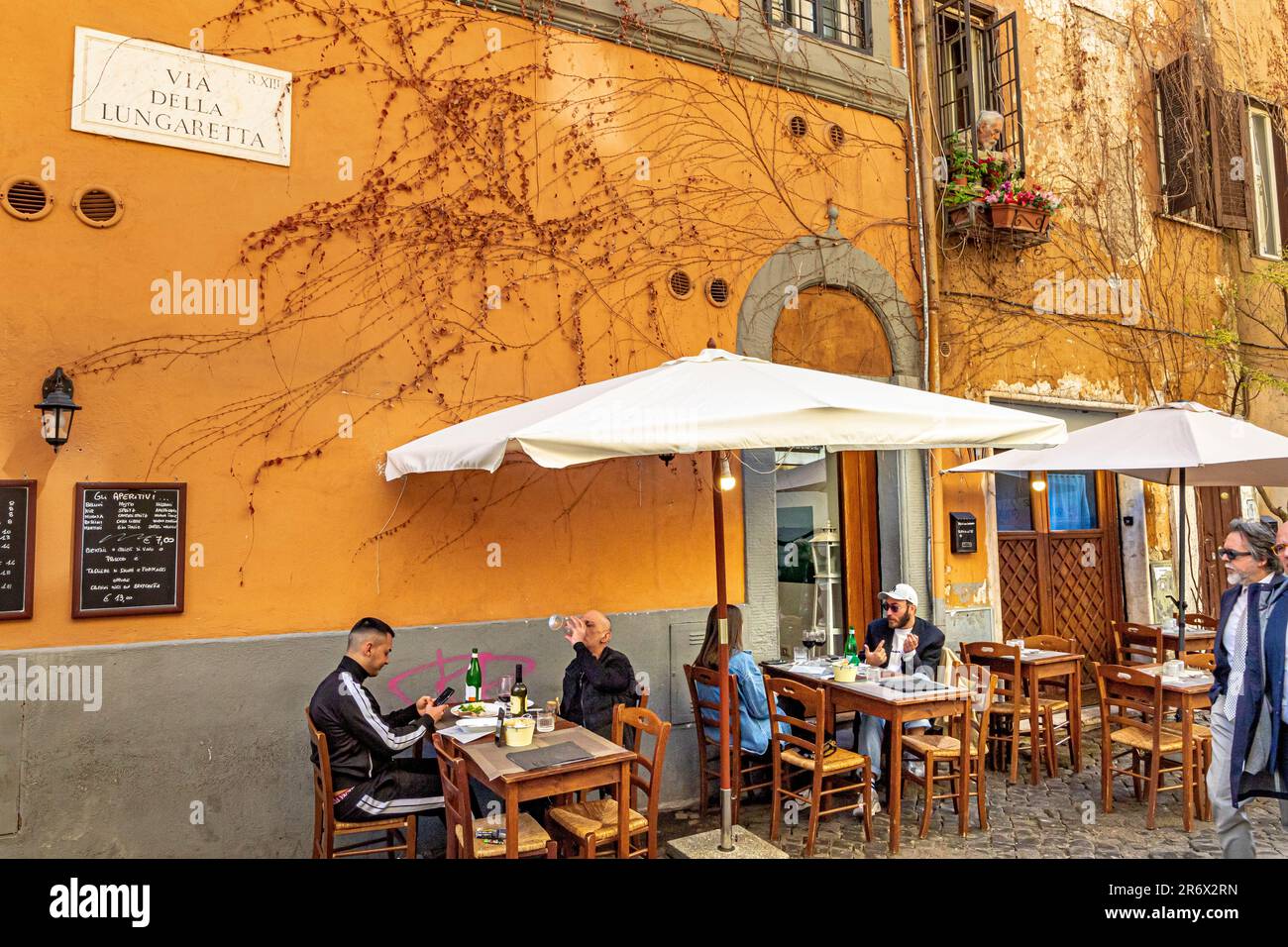 People sitting down at tables outside a restaurant in Trastevere, Rome ...