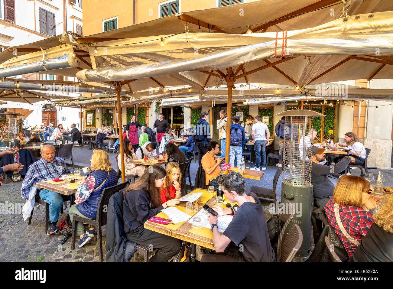 People sitting down at tables outside a restaurant in Trastevere, Rome ...