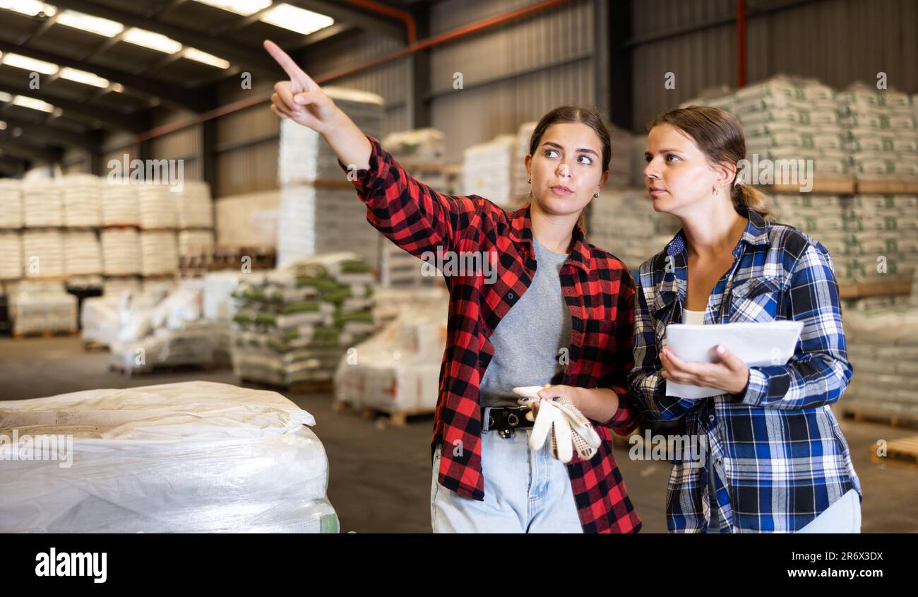 Women working in warehouse, talking about job Stock Photo - Alamy