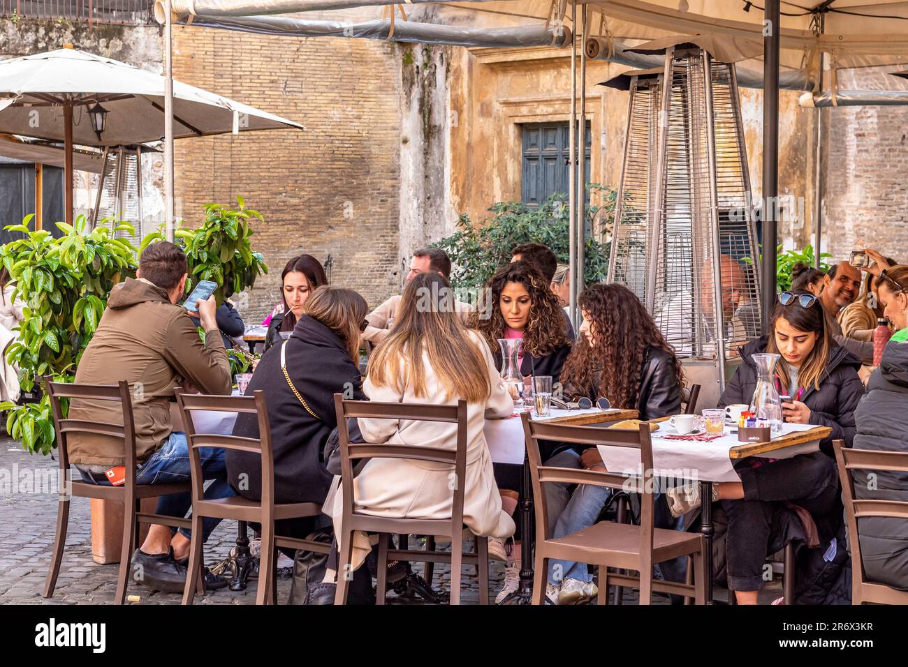 People sitting down at tables outside a Trastevere restaurant, Rome ...