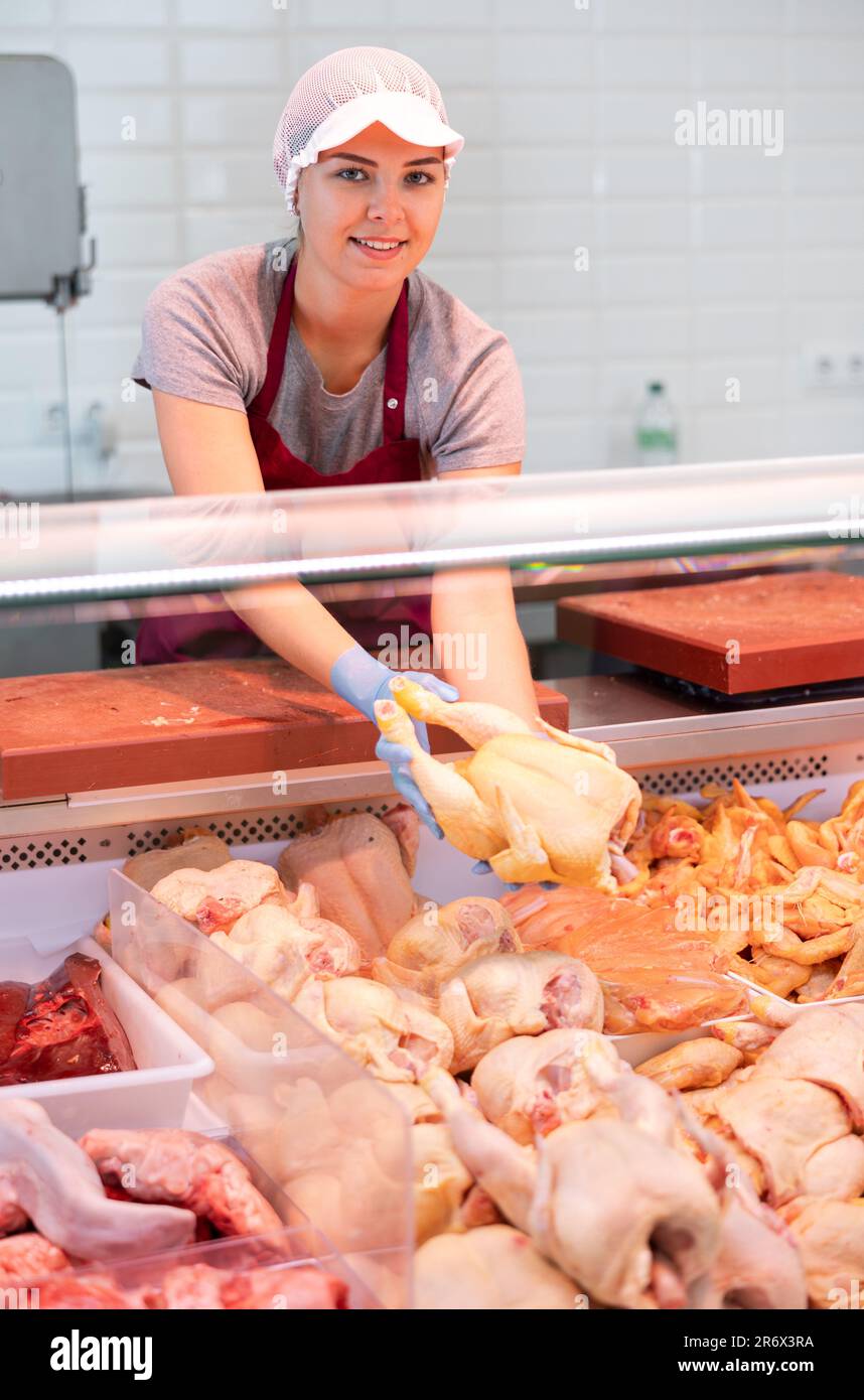 Female seller took out dressed chicken carcass from case refrigerator ...