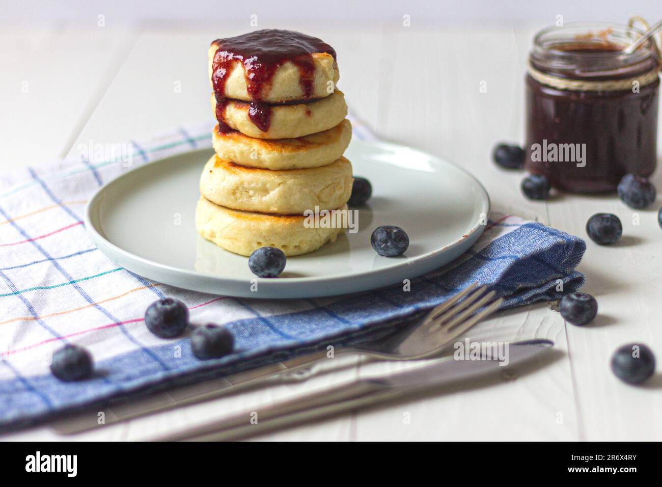 Syrniki or cottage cheese fritters with blueberry jam. Traditional ...