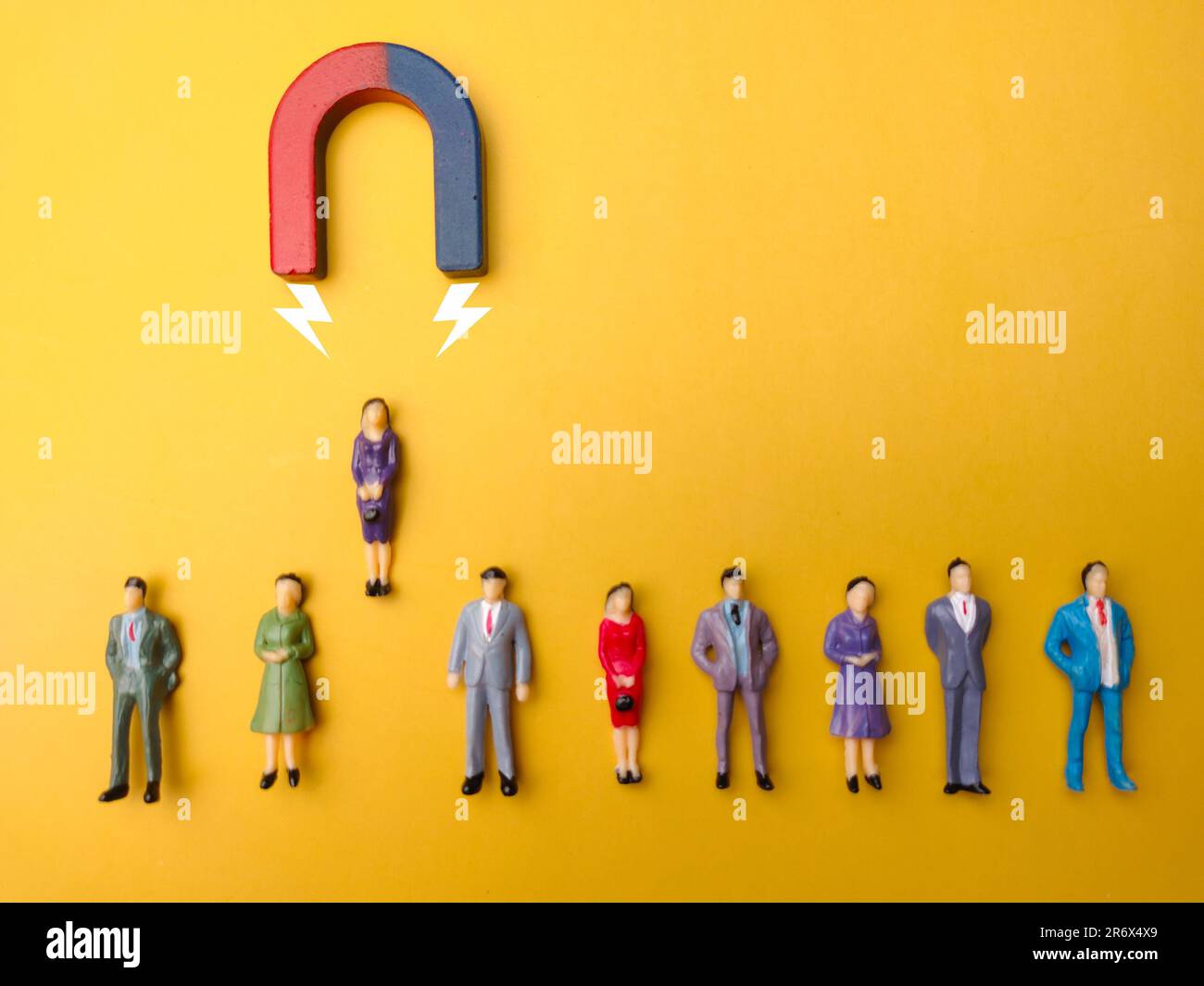 An array of figurines arranged in a pattern with a magnet and an arrow ...