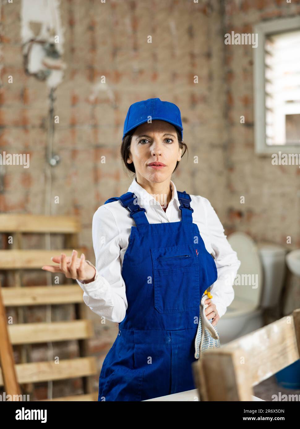 Woman construction worker posing inside house under renovation Stock ...