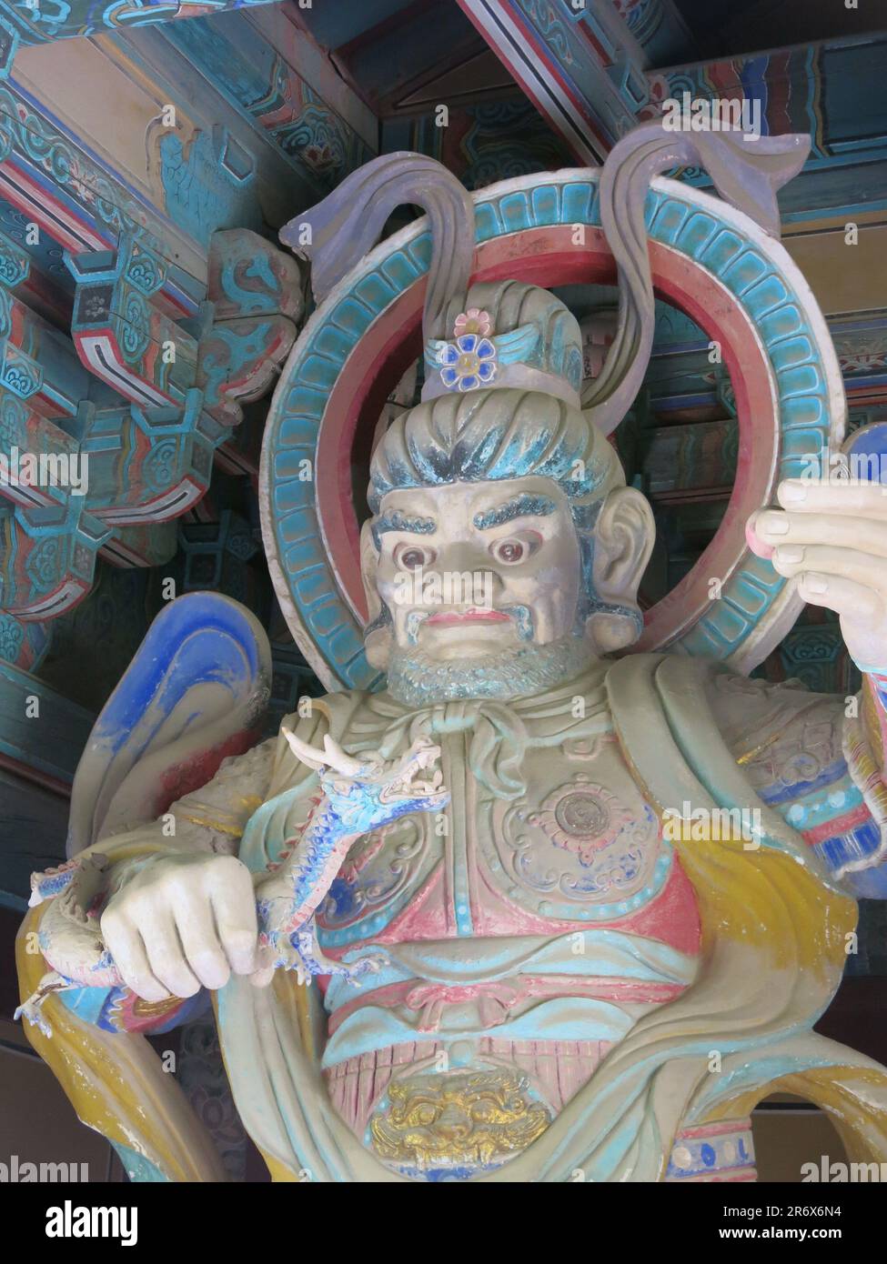 Close-up of the wooden statue of Virupaksa holding his dragon, guardian ...