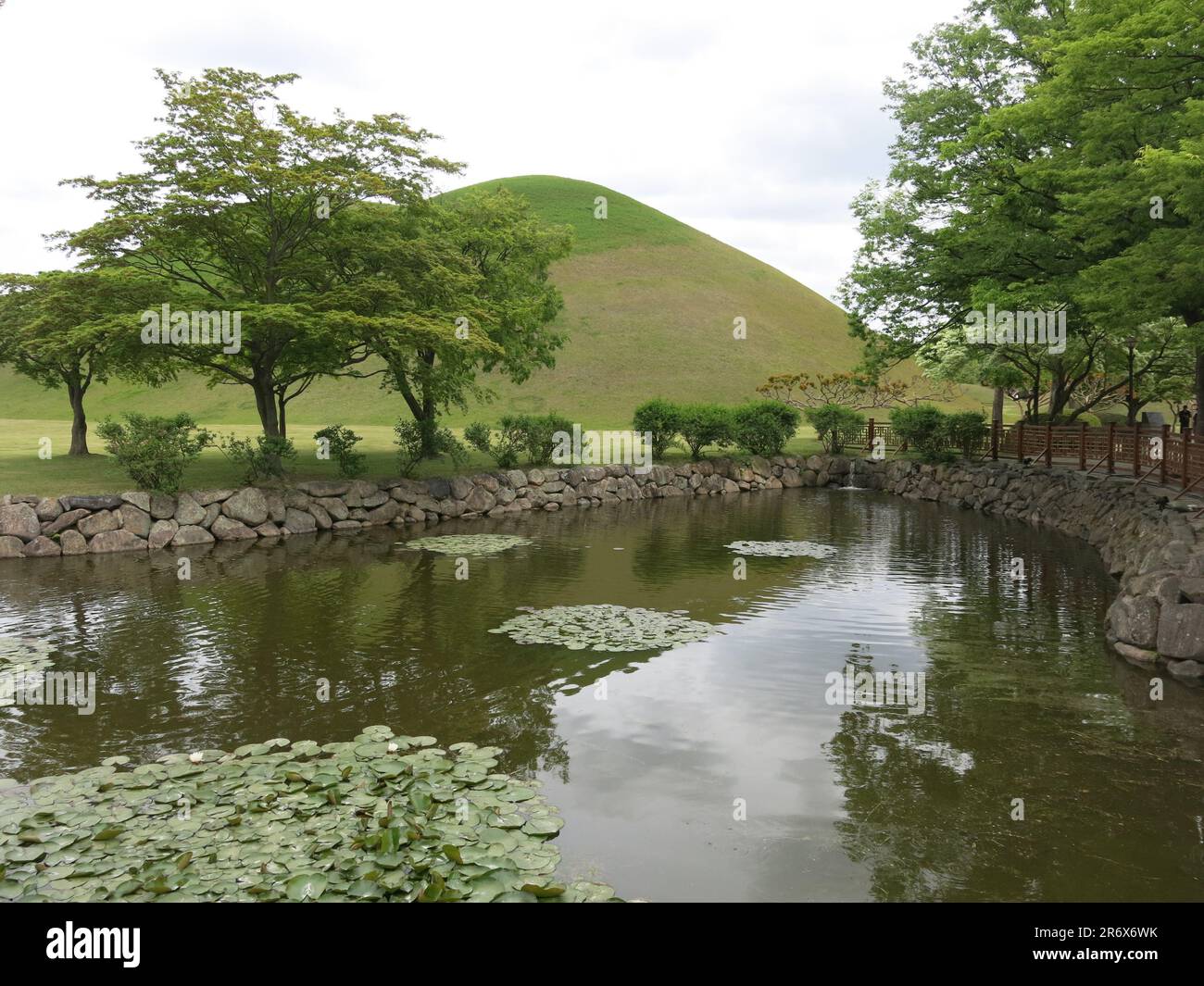 View of the grassy hillocks and lake within the Tumuli Park, Gyeongju ...