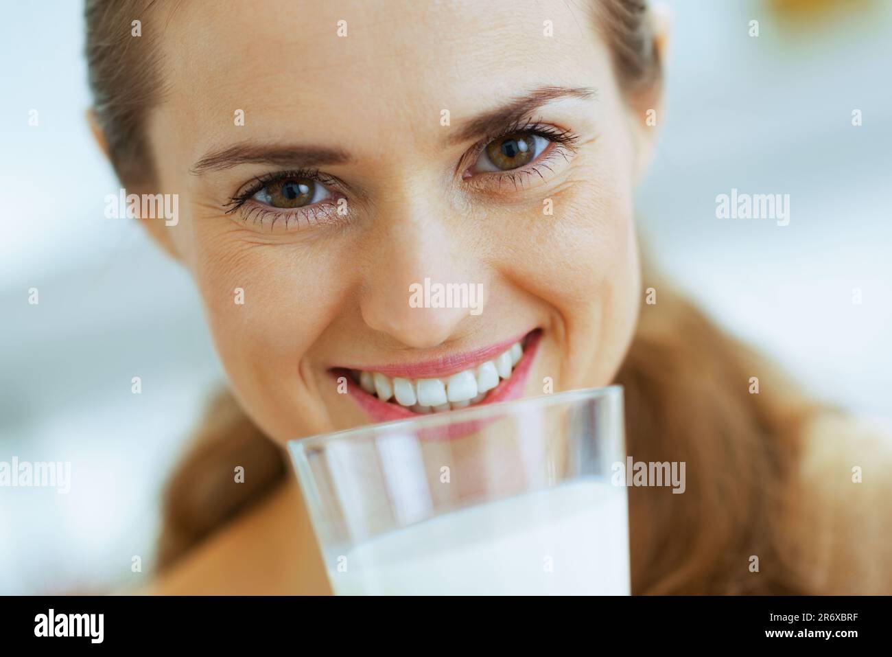 Happy young woman drinking milk Stock Photo - Alamy
