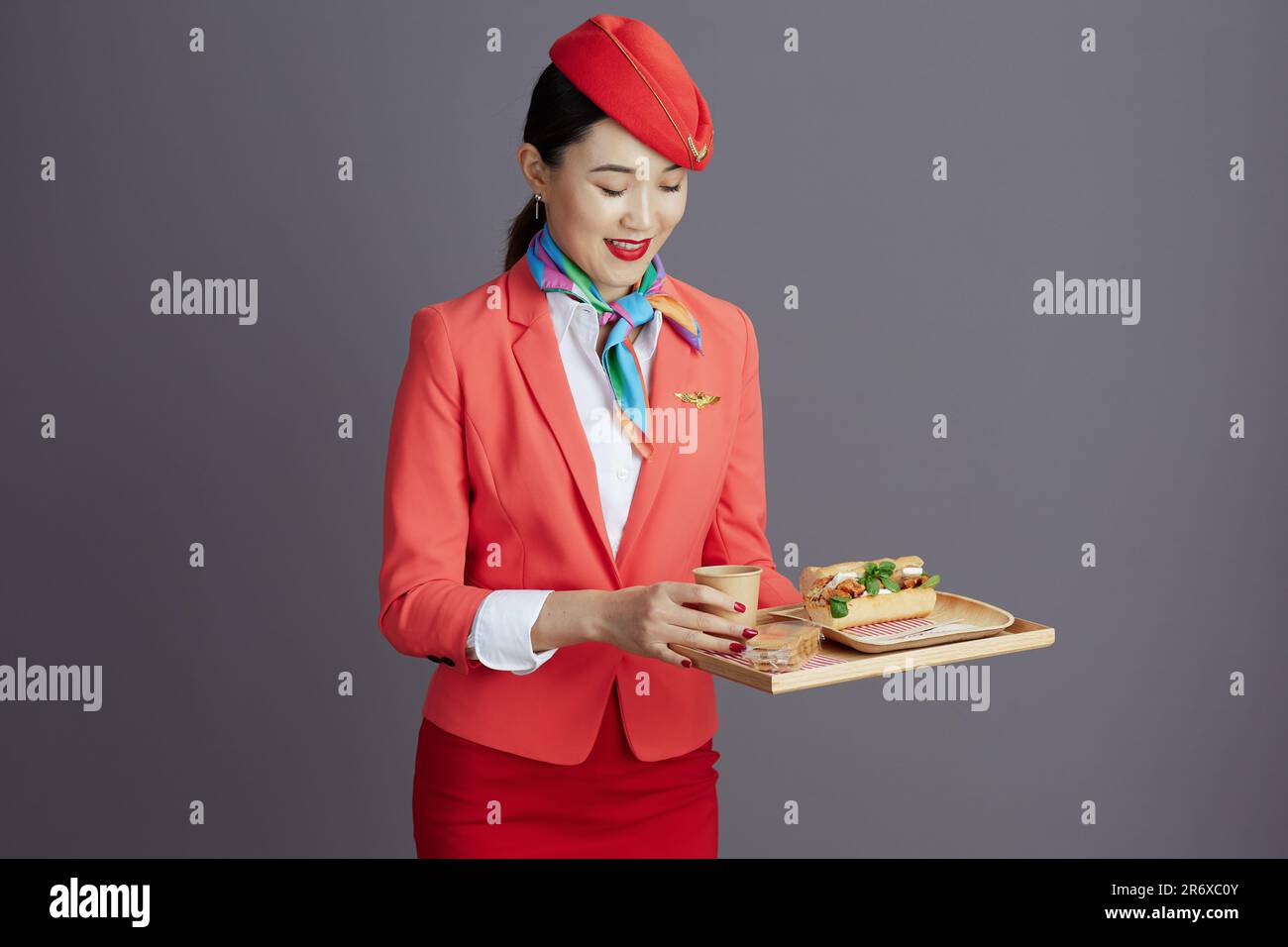 happy elegant air hostess asian woman in red skirt, jacket and hat ...