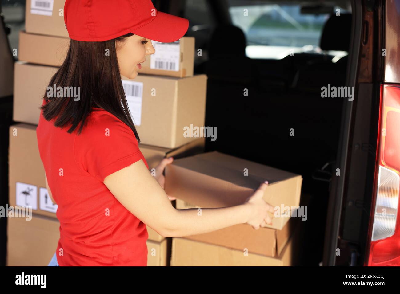 Courier taking parcel from delivery van outdoors Stock Photo - Alamy