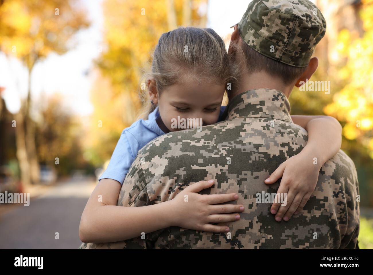 Daughter hugging her father in Ukrainian military uniform on city ...