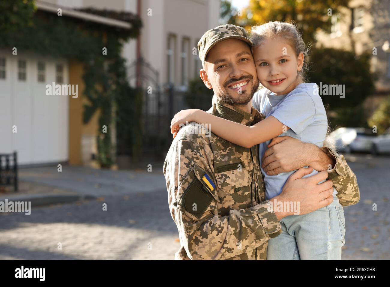 Father in Ukrainian military uniform and his daughter on city street ...