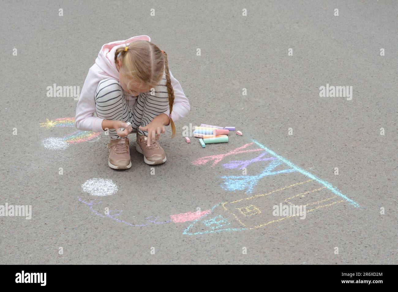 Little child drawing happy family with chalk on asphalt Stock Photo - Alamy