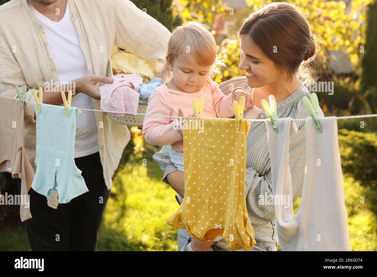 Happy family near washing line with drying clothes in backyard Stock ...
