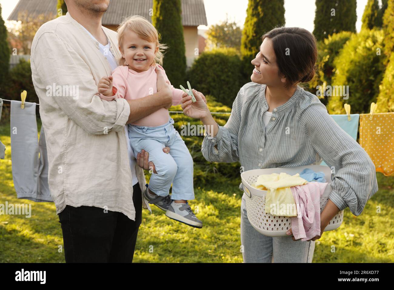Happy family near washing line with drying clothes in backyard Stock ...