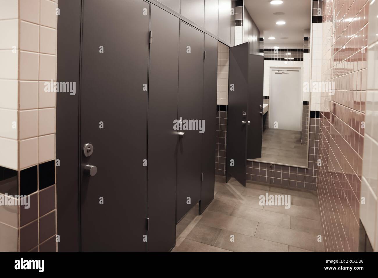 Public toilet interior with stalls and tiled walls Stock Photo - Alamy