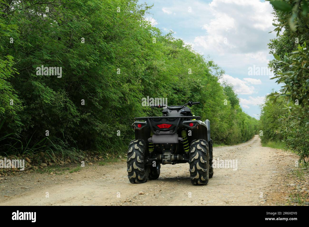 Black quad bike on pathway near trees outdoors Stock Photo - Alamy