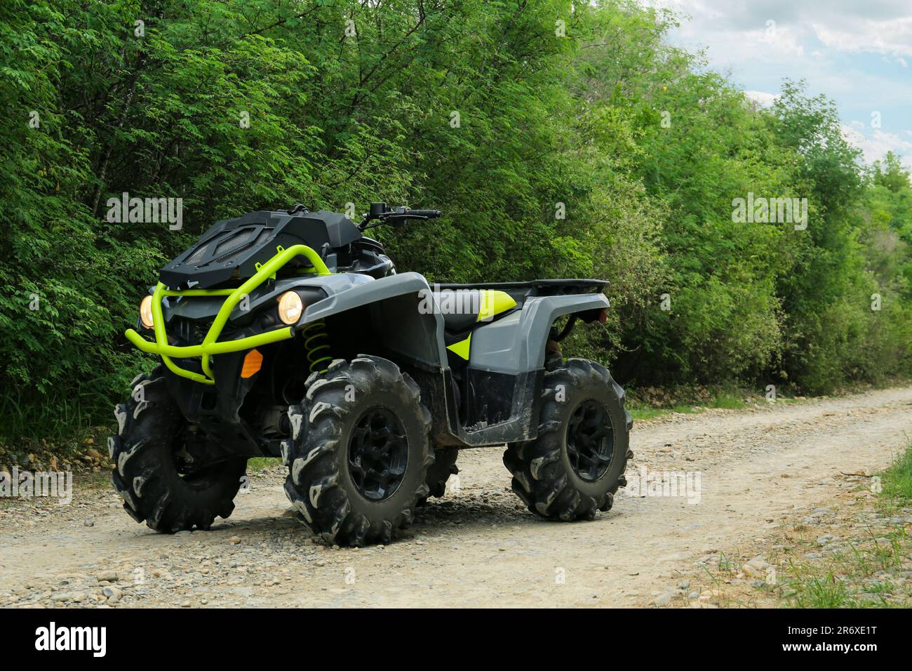 Modern quad bike on pathway near trees outdoors Stock Photo - Alamy