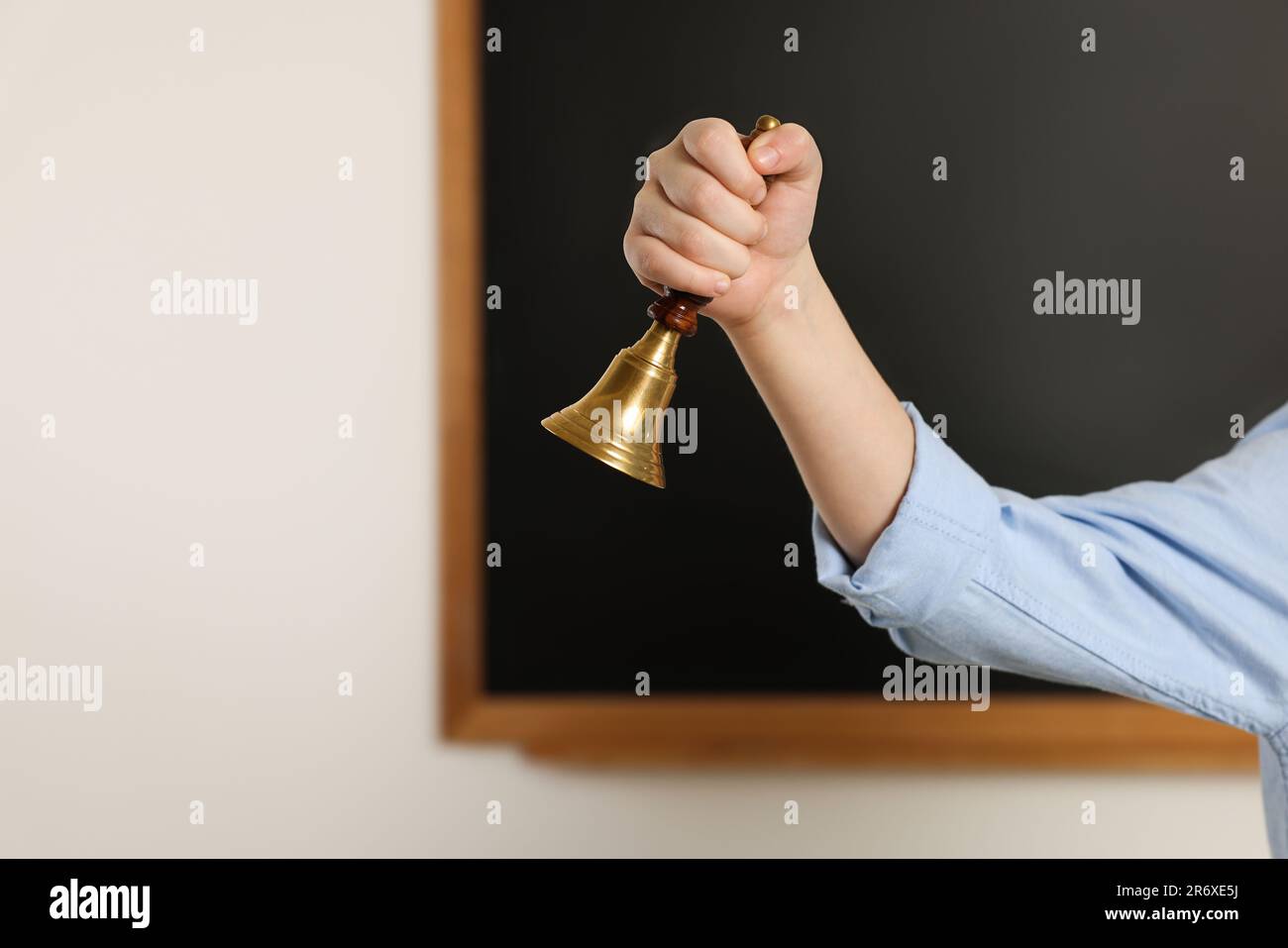 Boy ringing school bell in classroom, closeup. Space for text Stock ...