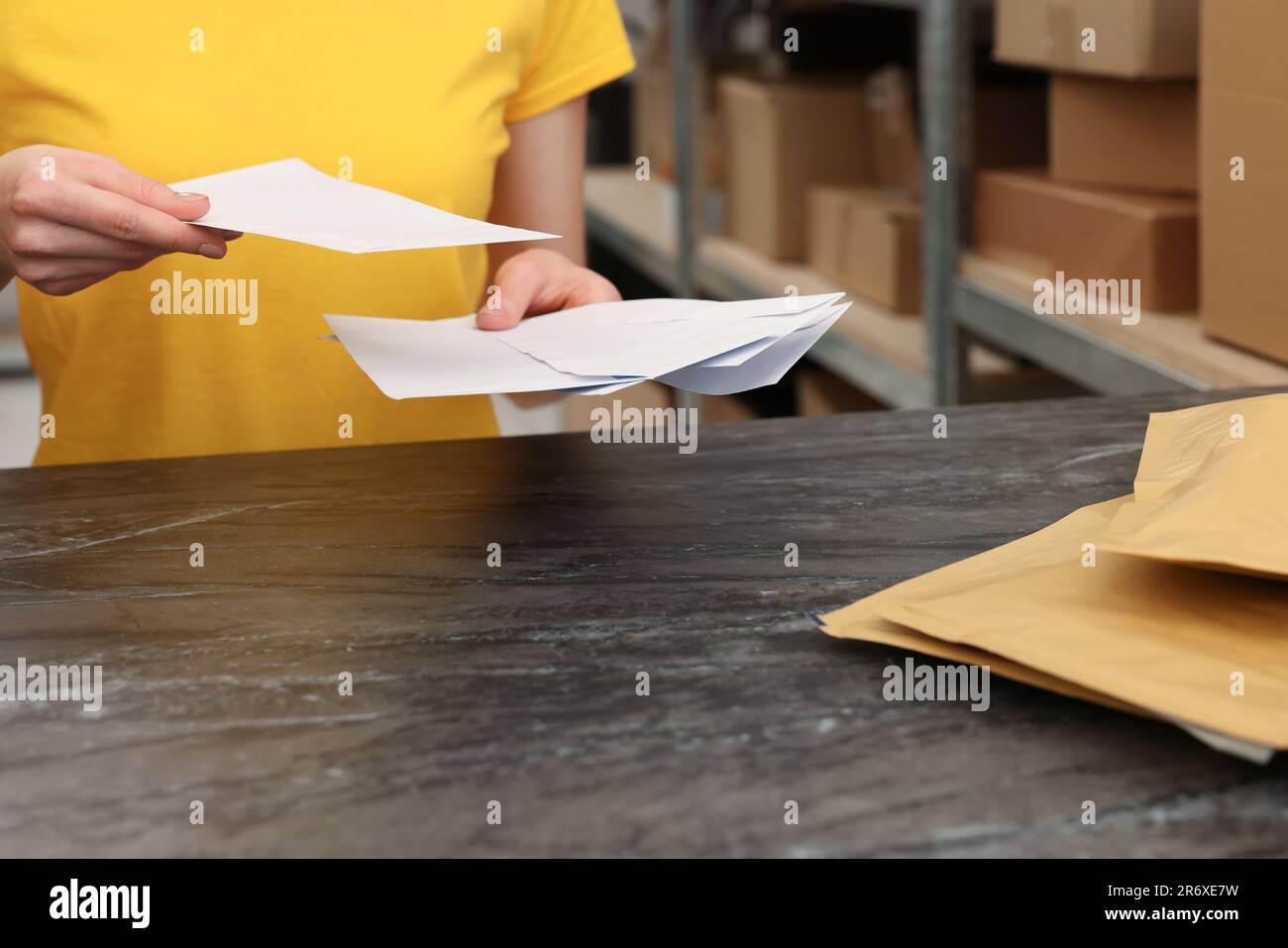 Post office worker with envelopes at counter indoors, closeup Stock ...