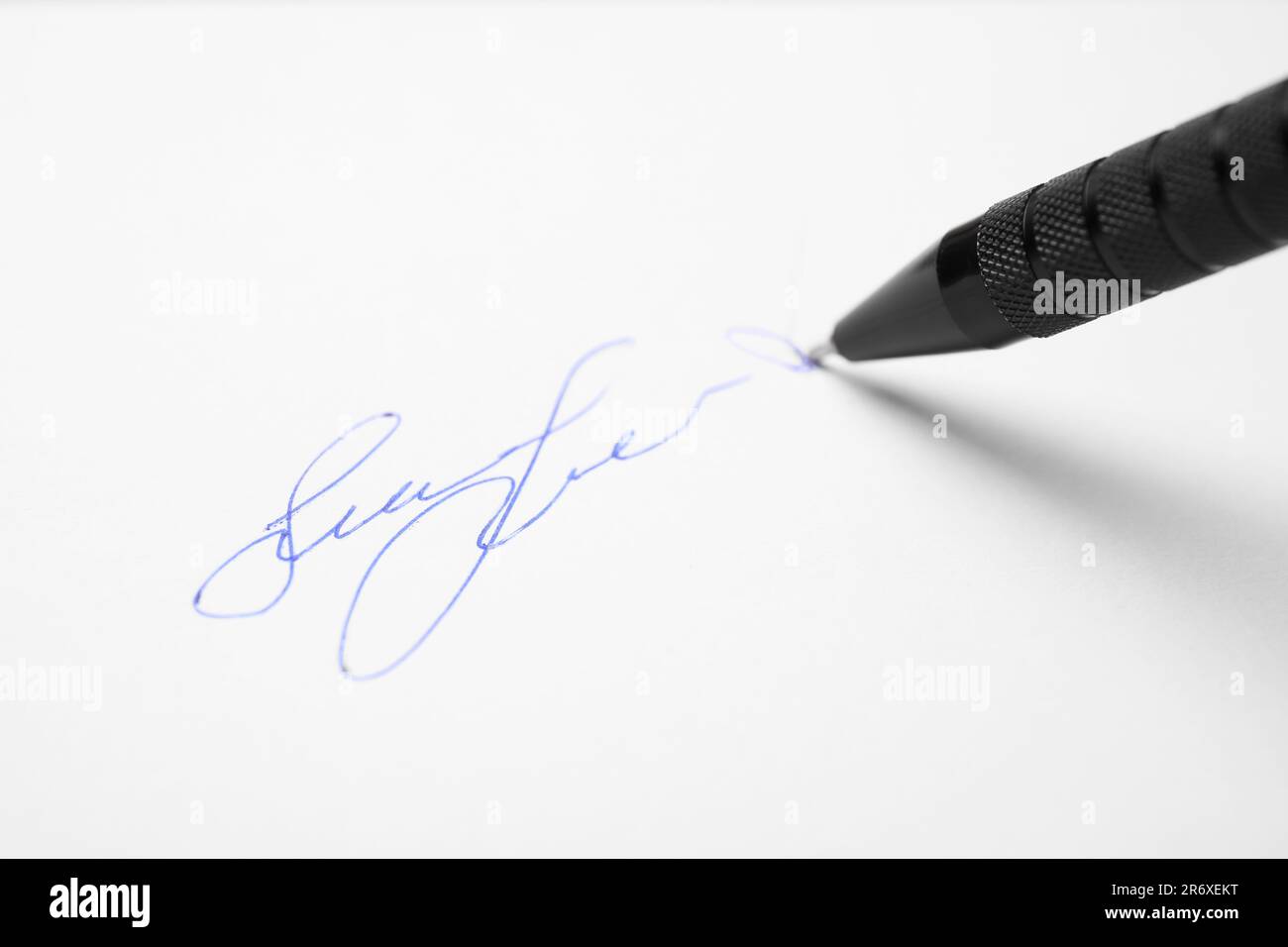 Signing on sheet of white paper with pen, closeup Stock Photo - Alamy