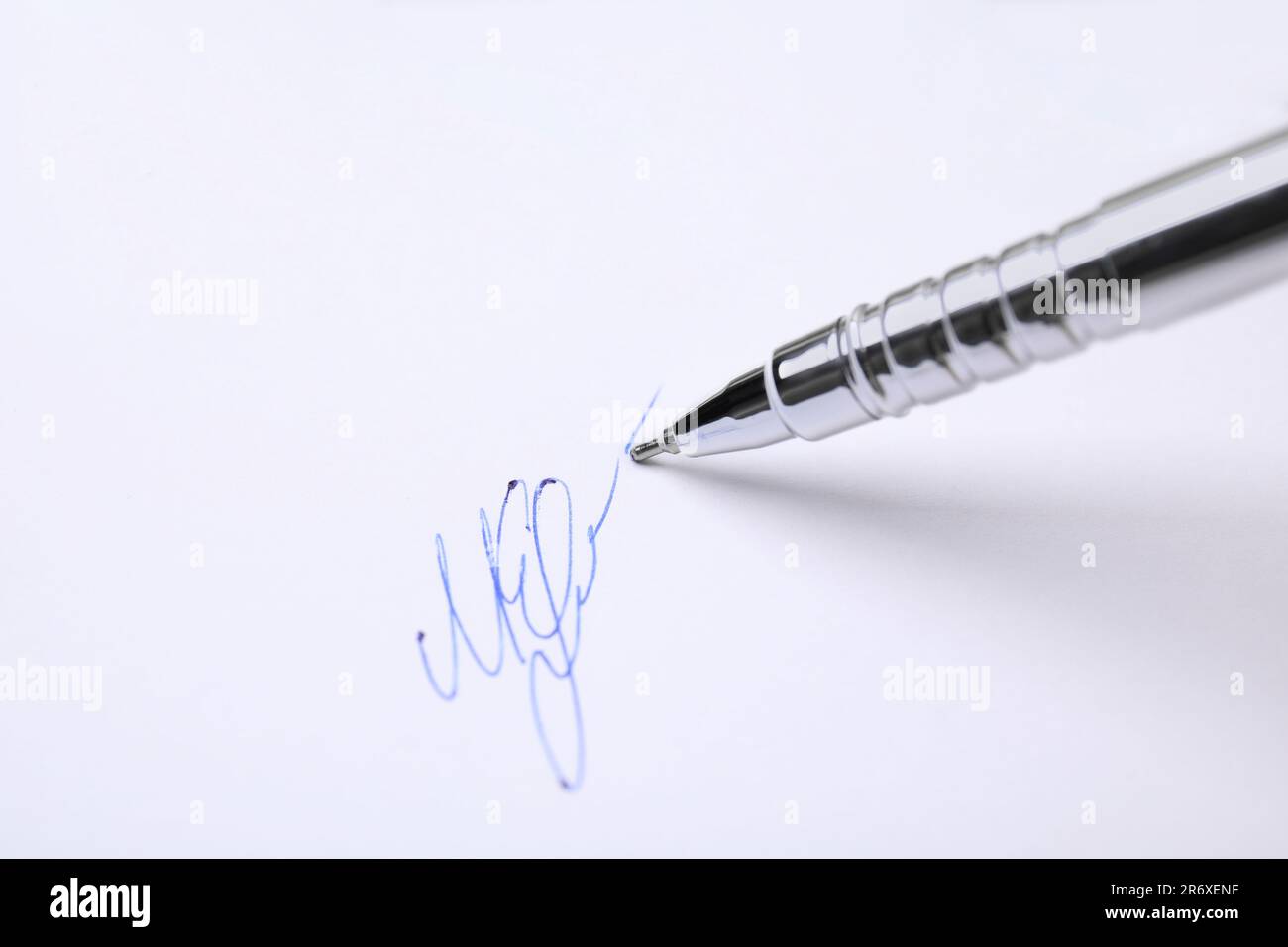 Signing on sheet of white paper with pen, closeup Stock Photo - Alamy