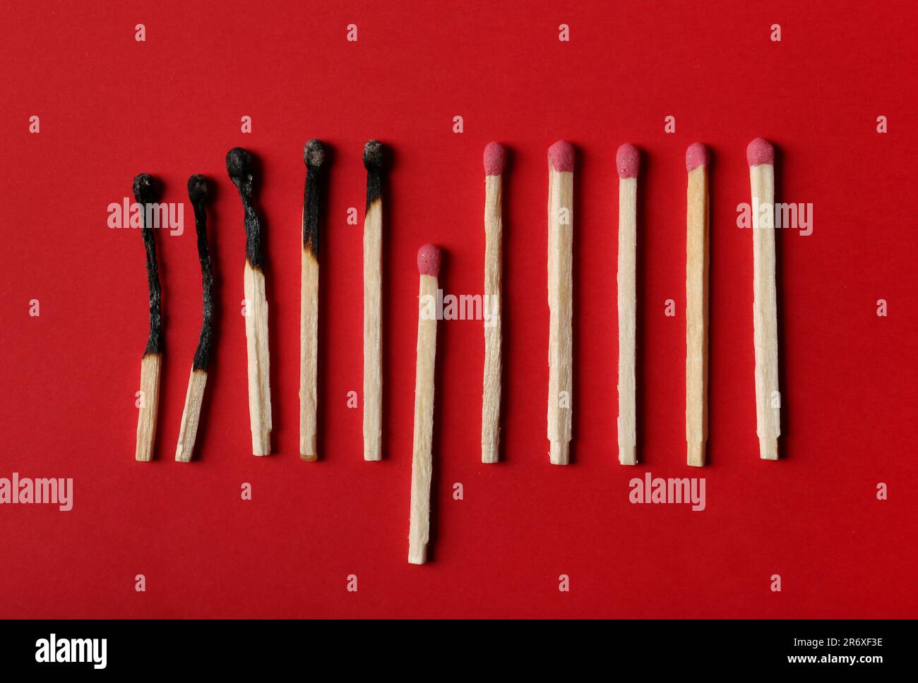 Burnt and whole matches on red background, flat lay. Stop destruction ...