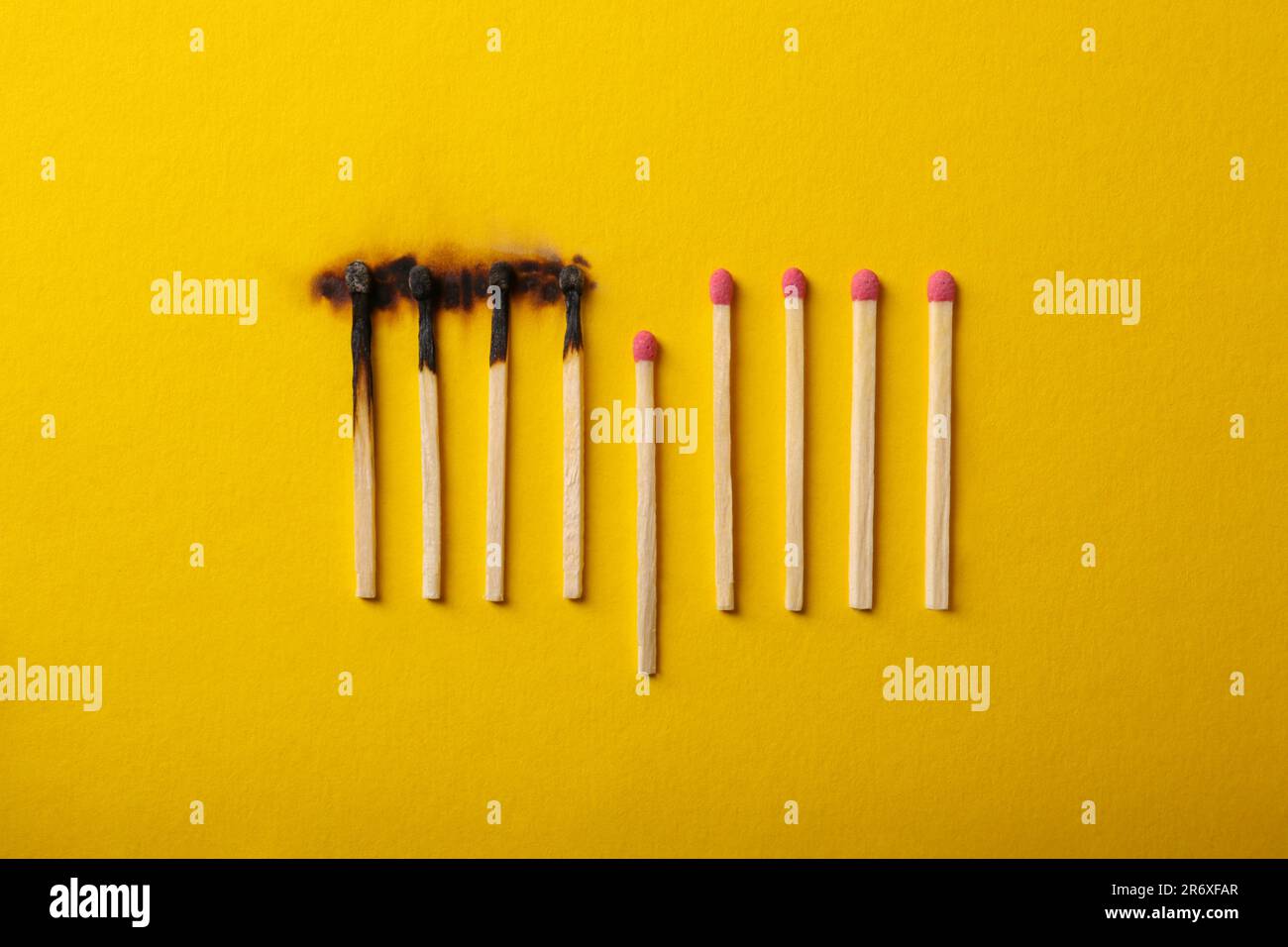 Burnt and whole matches on yellow background, flat lay. Stop ...