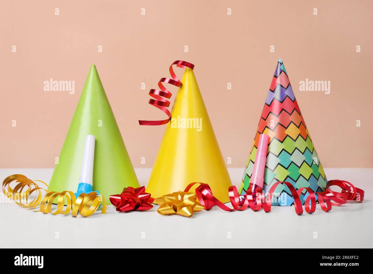 Colorful party hats, streamers and blowers on white table. Birthday ...