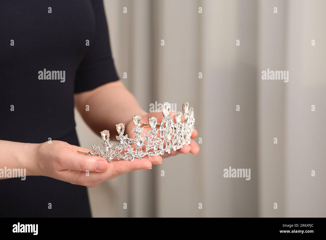 Woman holding luxurious tiara indoors, closeup. Space for text Stock ...