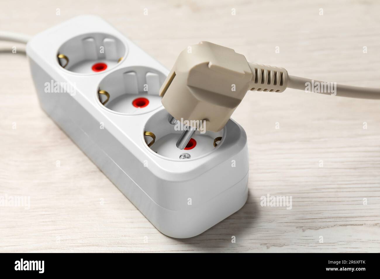 Extension cord with electrical plug on floor, closeup. Electrician's ...