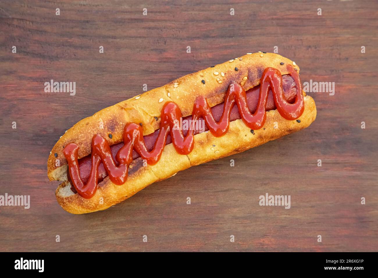 Fresh tasty hot dog with ketchup on wooden table, top view Stock Photo ...