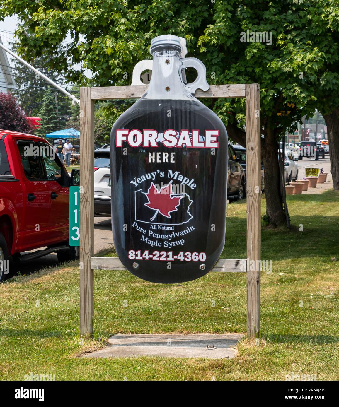 A sign in the shape of a glass syrup jug advertising maple syrup for ...