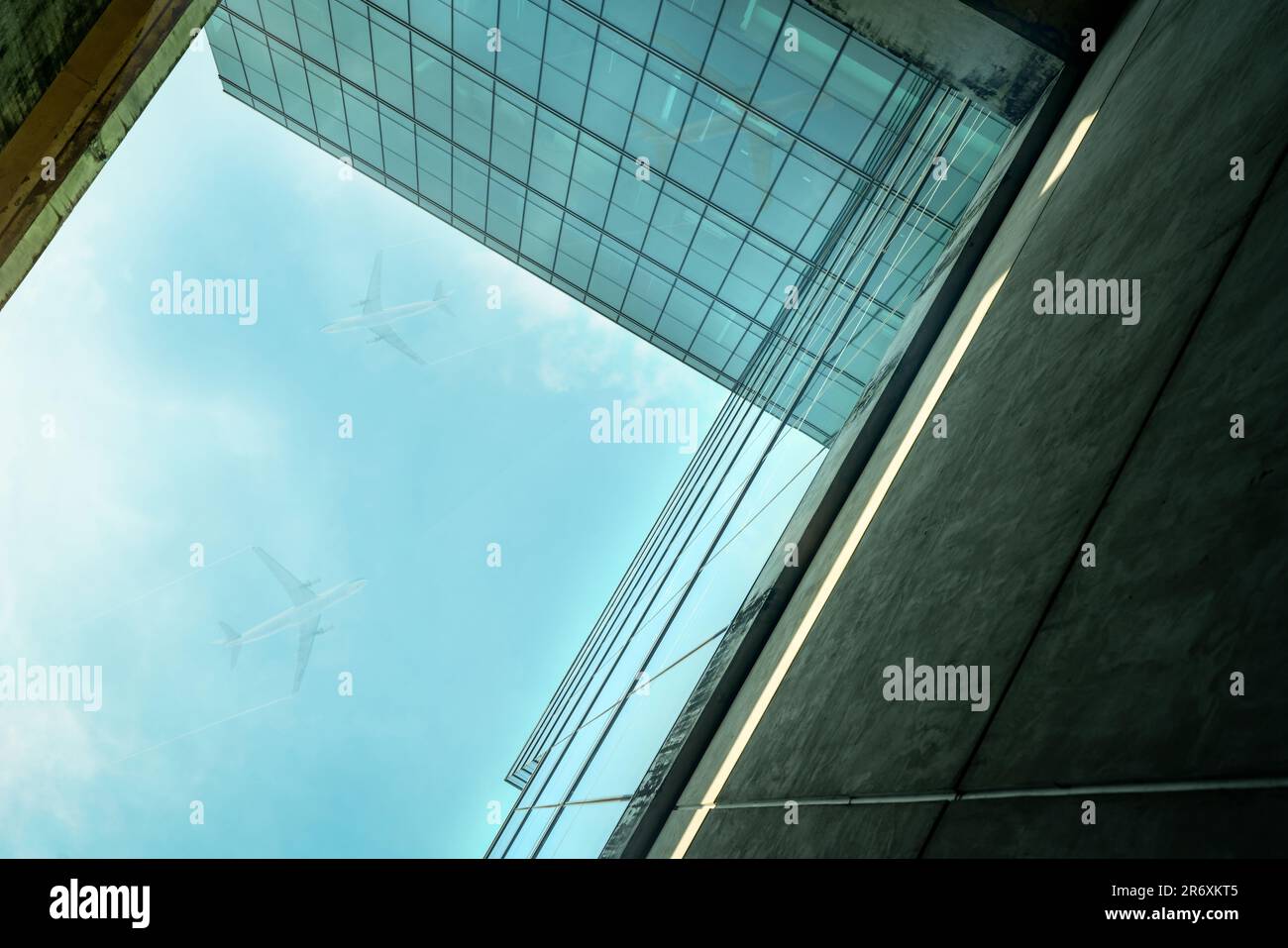Bottom up view of modern sustainable glass office building and airplane ...