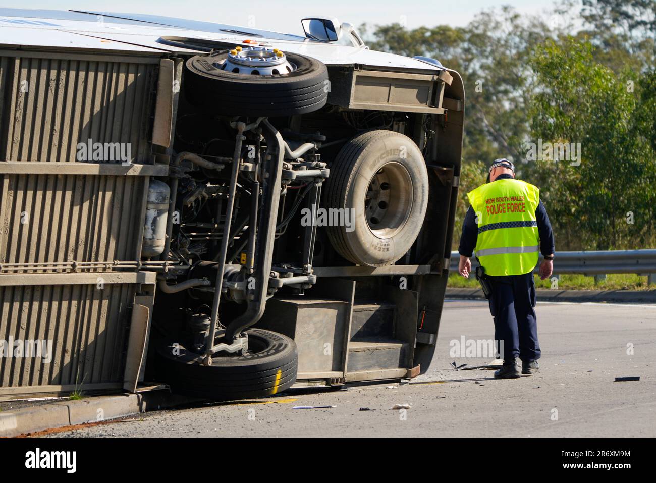 Police inspect underneath a bus that rolled onto its side near Greta in ...