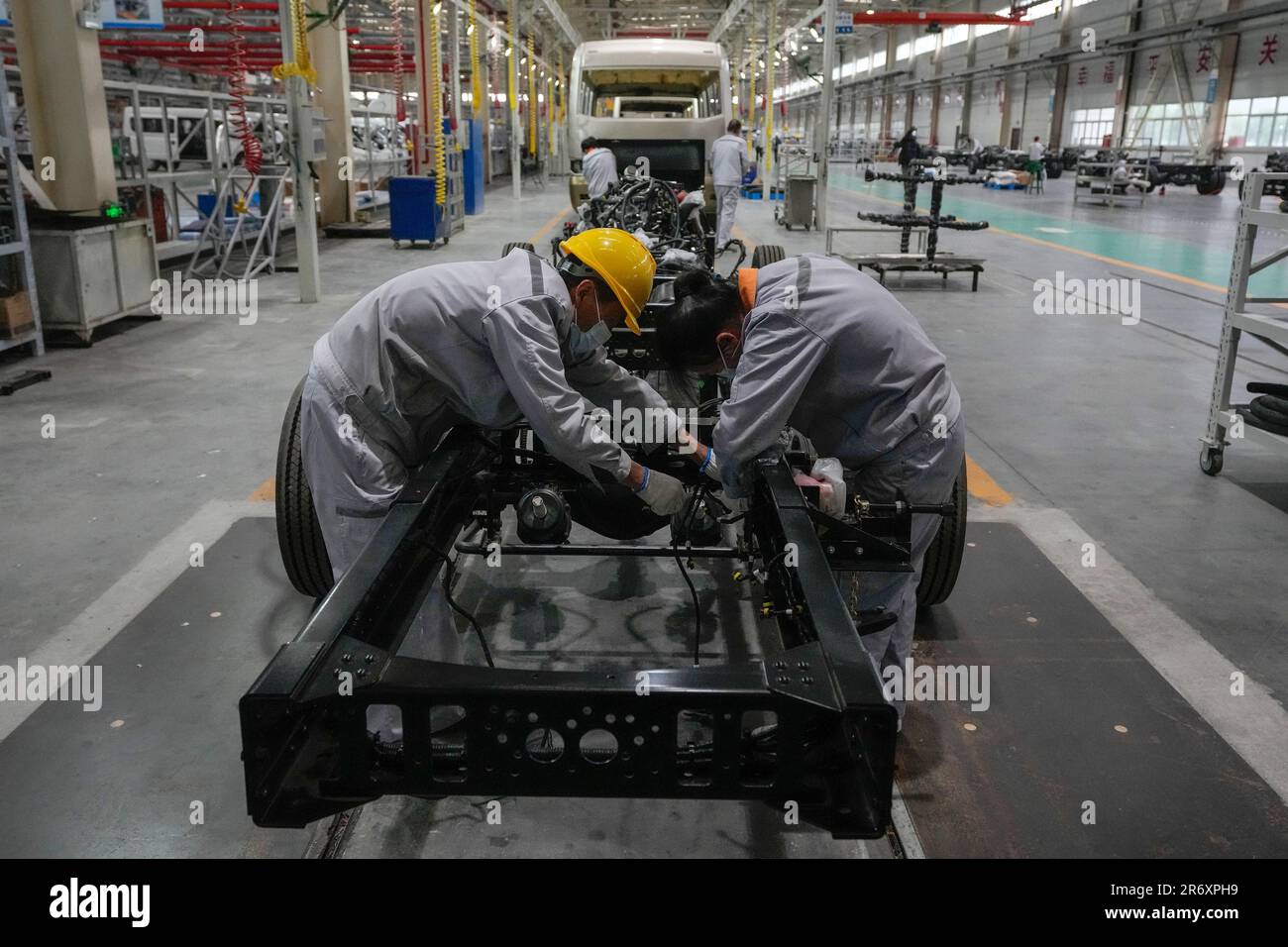 Workers assemble a chassis frame of a minibus at a Tenglong Automobile ...