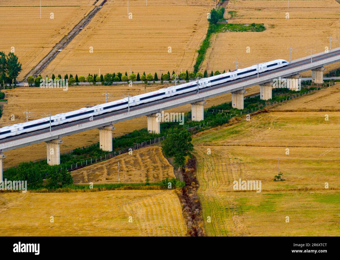 HUAI'AN, CHINA - JUNE 11, 2023 - High-speed trains pass through fields and villages in the ...