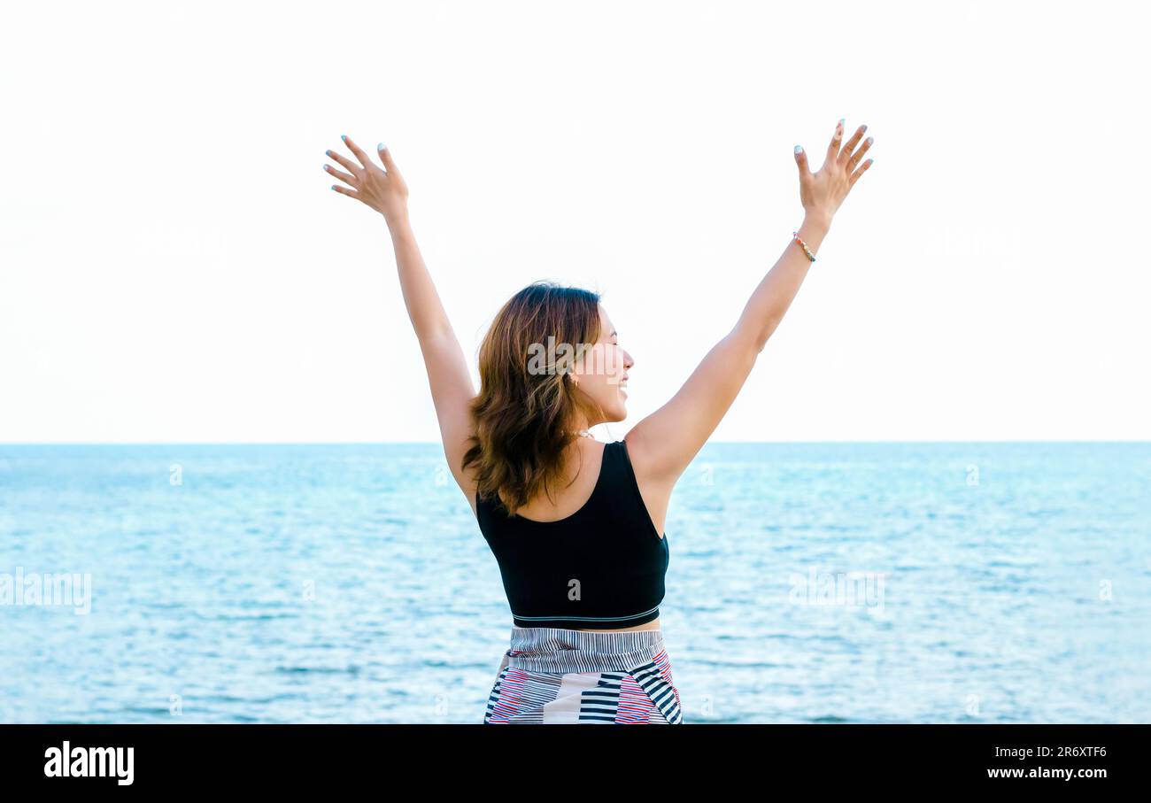 Back of Asian woman in black tank top closing eyes with happy raise ...