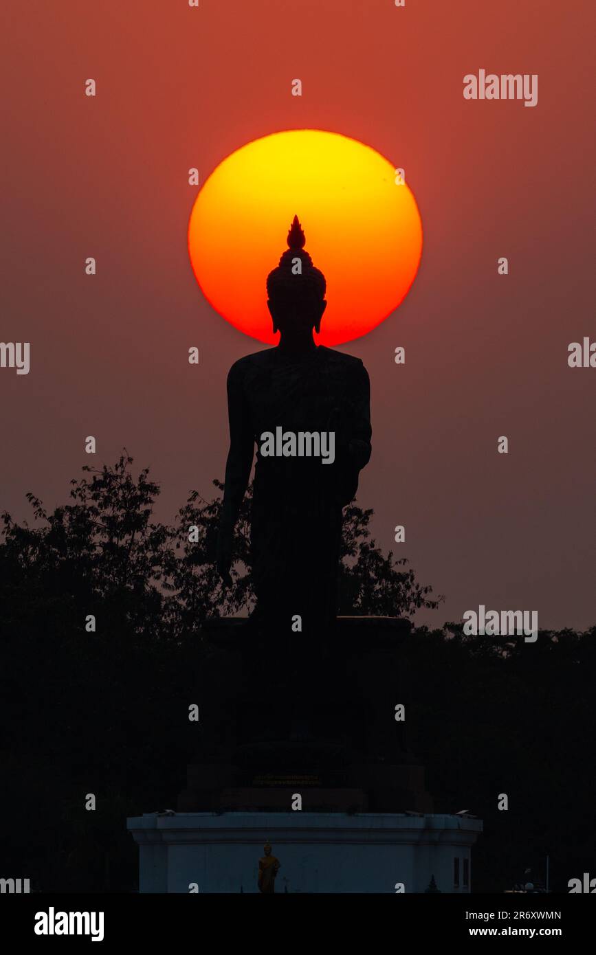 Head of statue of Buddha image surrounded by sun during sunset at Budda ...