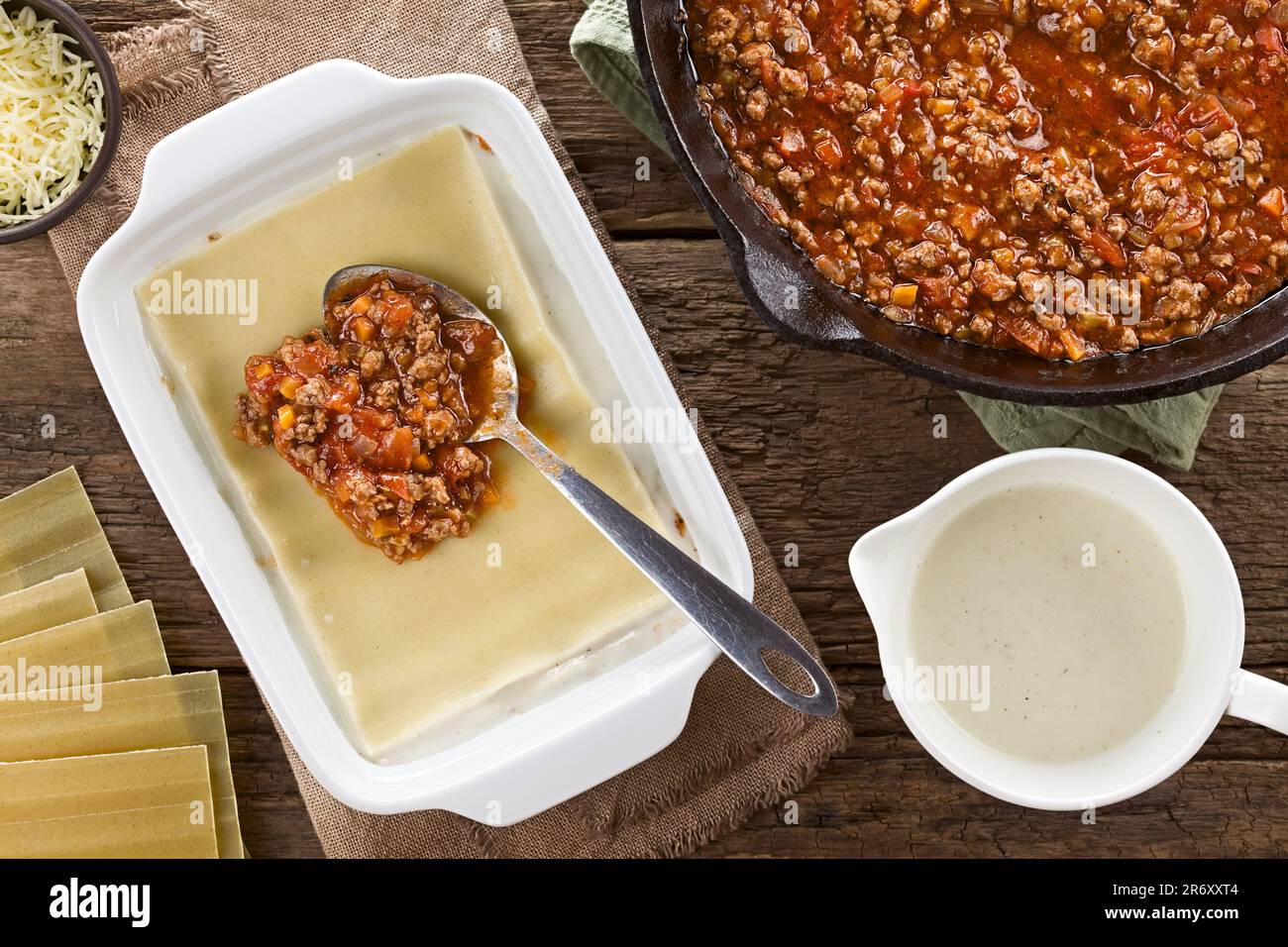Preparing Lasagna in Rectangular Casserole Dish. Bolognese sauce on top ...