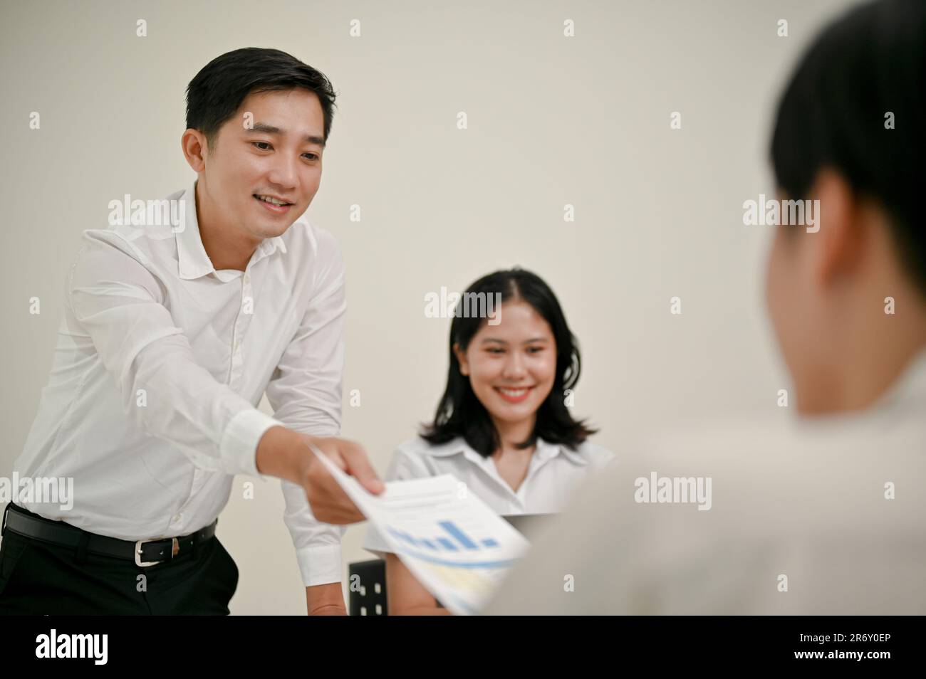 Young asian worker handing document hi-res stock photography and images ...