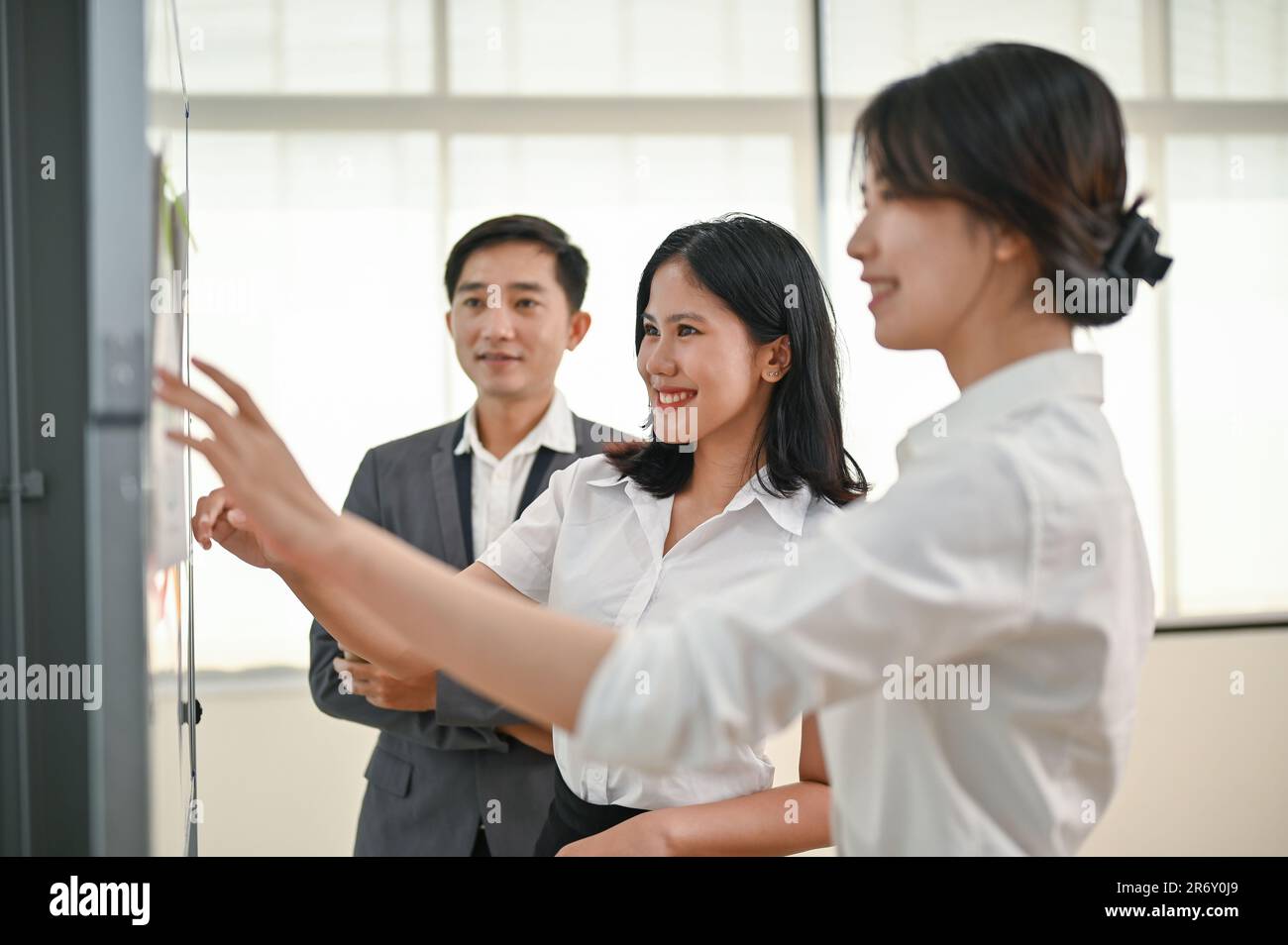 An attractive and confident young Asian female marketing worker shared her ideas with her ...