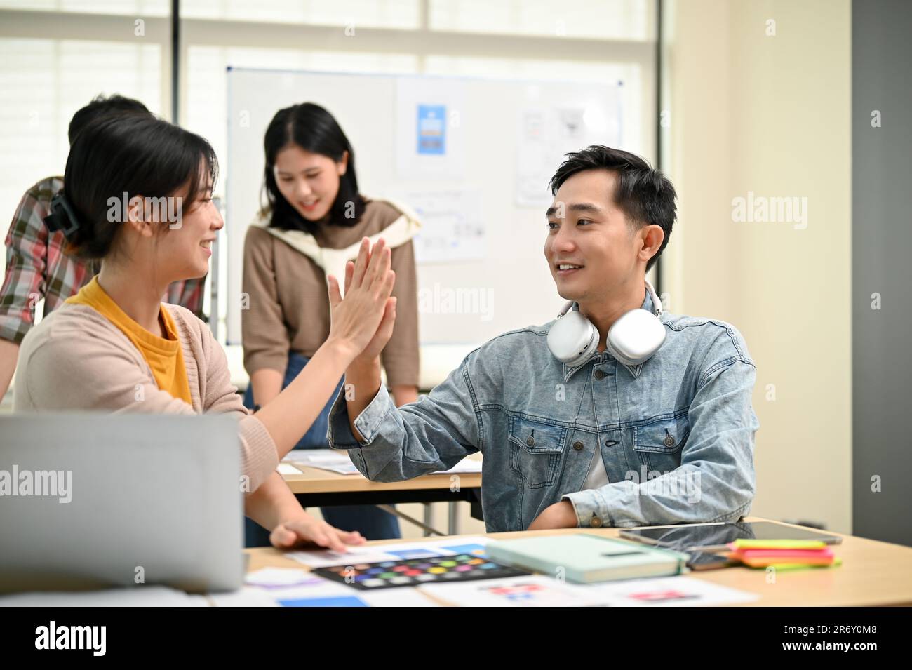 A professional Asian male developer giving high five to his colleague ...